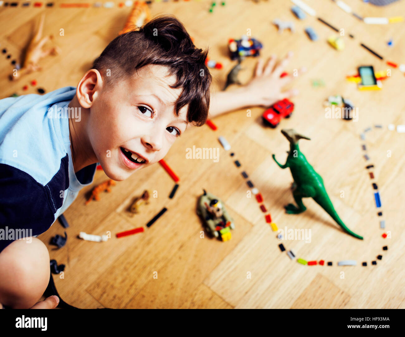 little cute preschooler boy among toys lego at home happy smiling ...