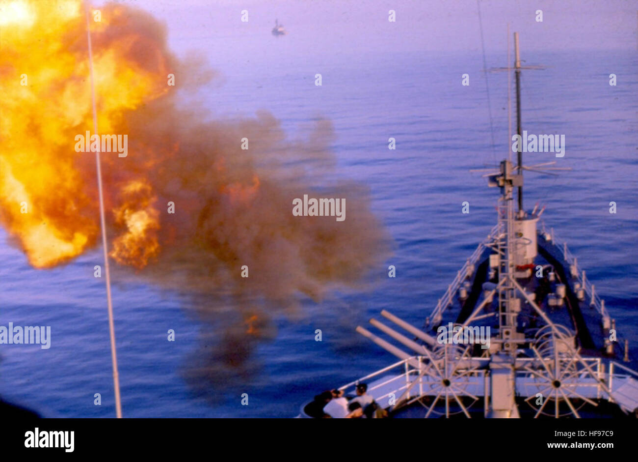 The guided-missile light cruiser CLG-5 fires its forward guns during ...
