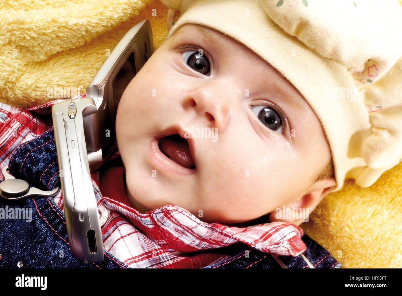 Baby wearing a hat "talking" on a mobile phone Stock Photo - Alamy