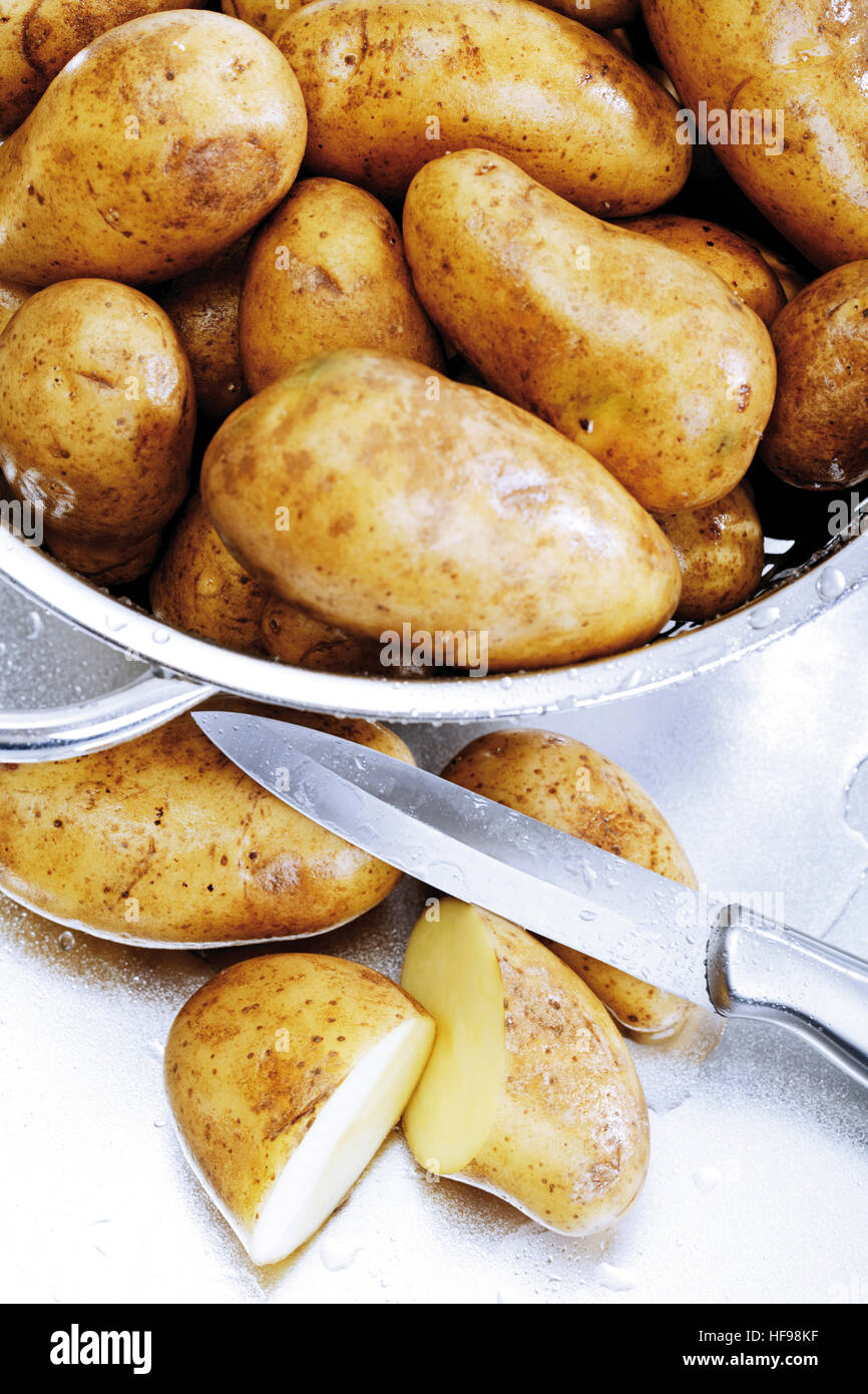 Potatoes in sieve with peeling knife Stock Photo - Alamy