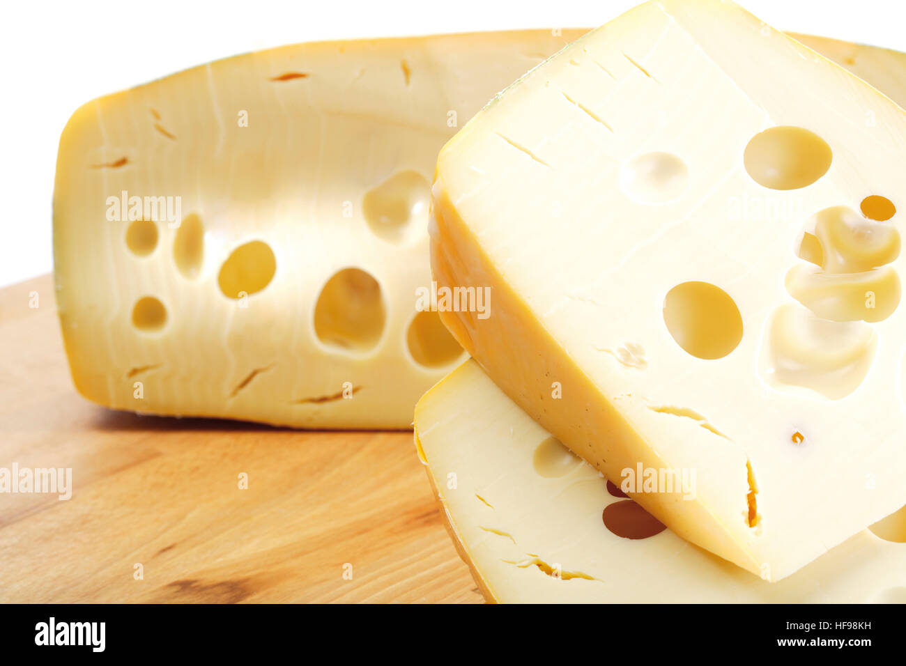 A piece of Leerdamer cheese and half a cheese wheel in the background ...