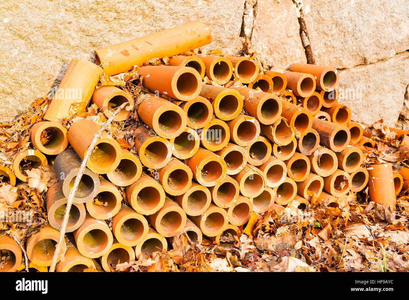 Small stack of red concrete tubes against stone wall in fall. Stacks ...