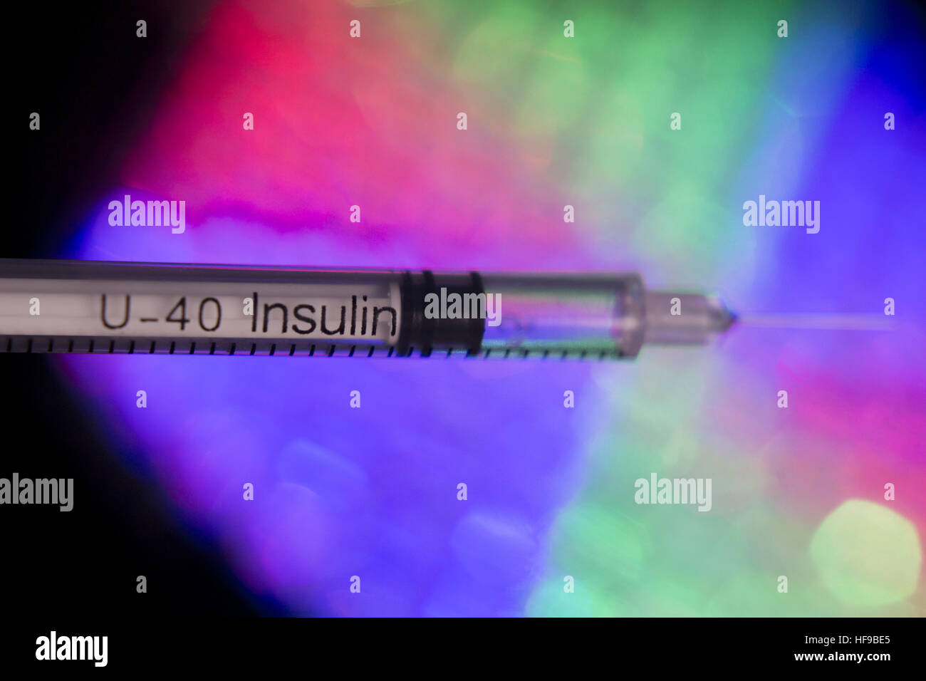 Insulin syringe on multicolored background out of focus Stock Photo - Alamy