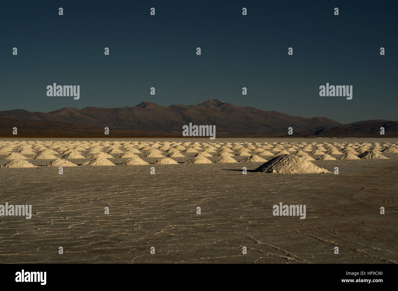 Salt mining with mountains and blue sky background Stock Photo - Alamy