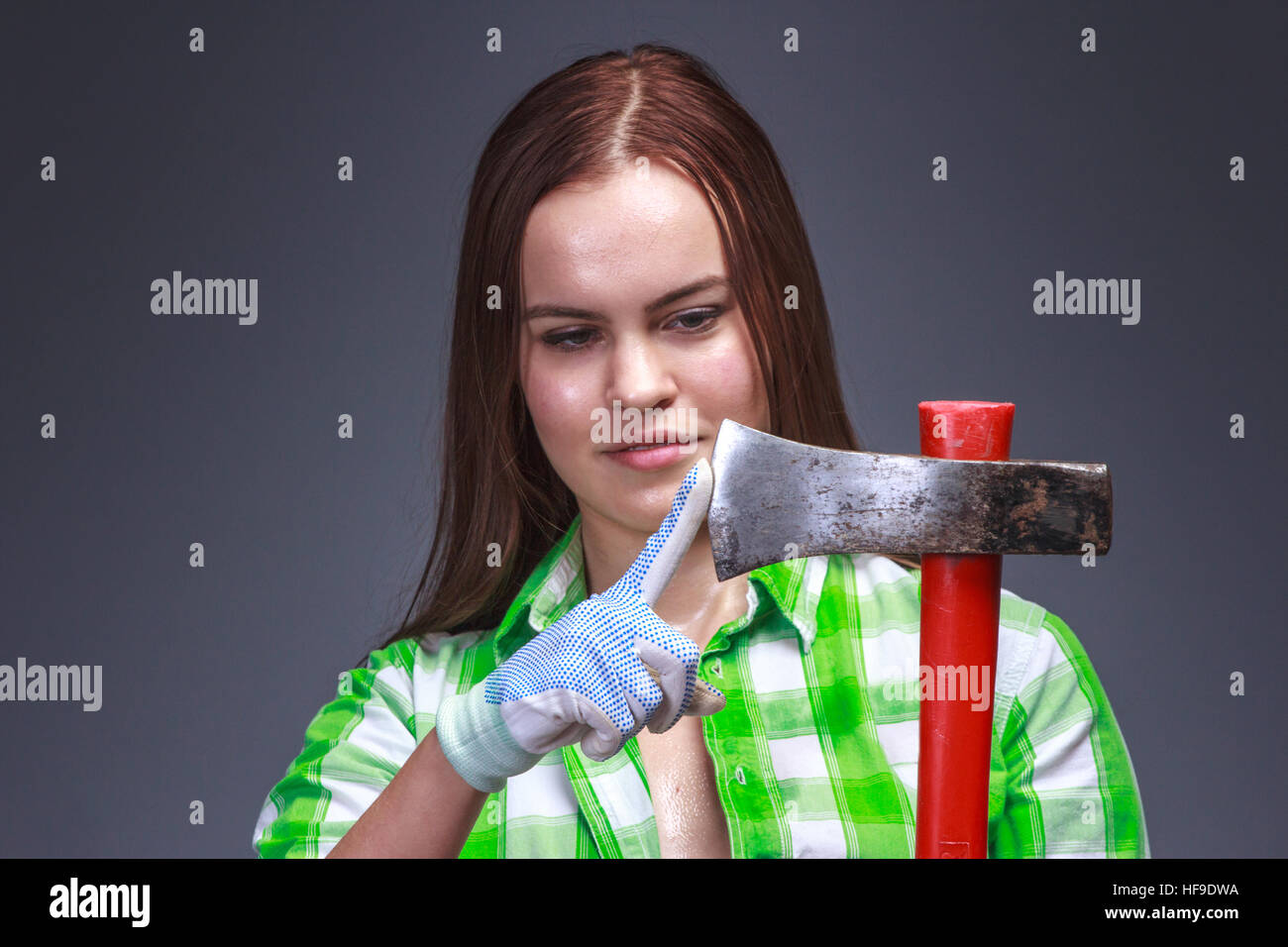 Pretty Woman checks how acutely sharpened axe Stock Photo - Alamy
