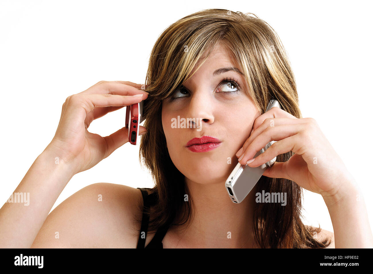 Young woman talking on two mobile phones simultaneously Stock Photo - Alamy