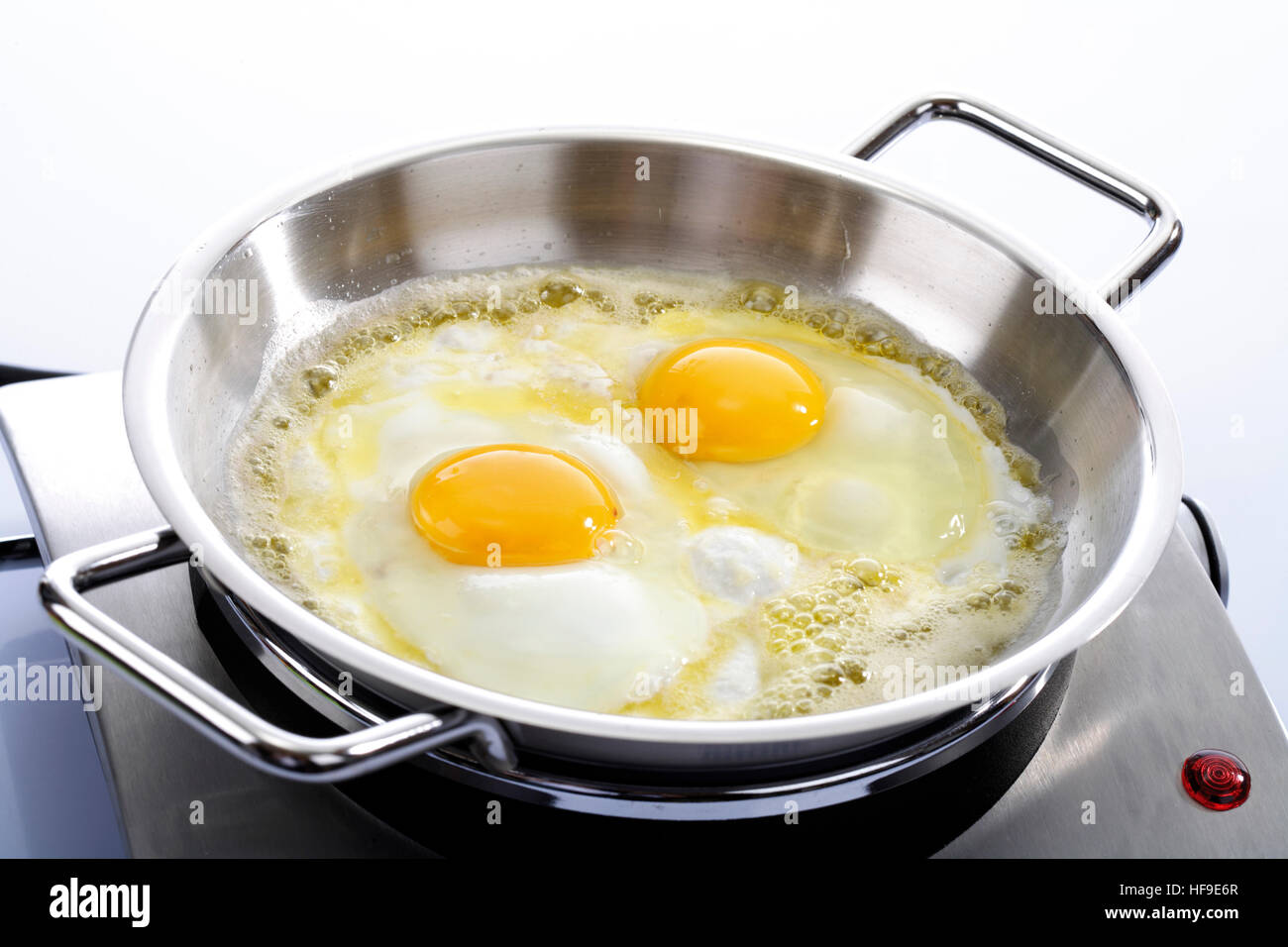 Two eggs sunny-side up in a frying pan Stock Photo - Alamy