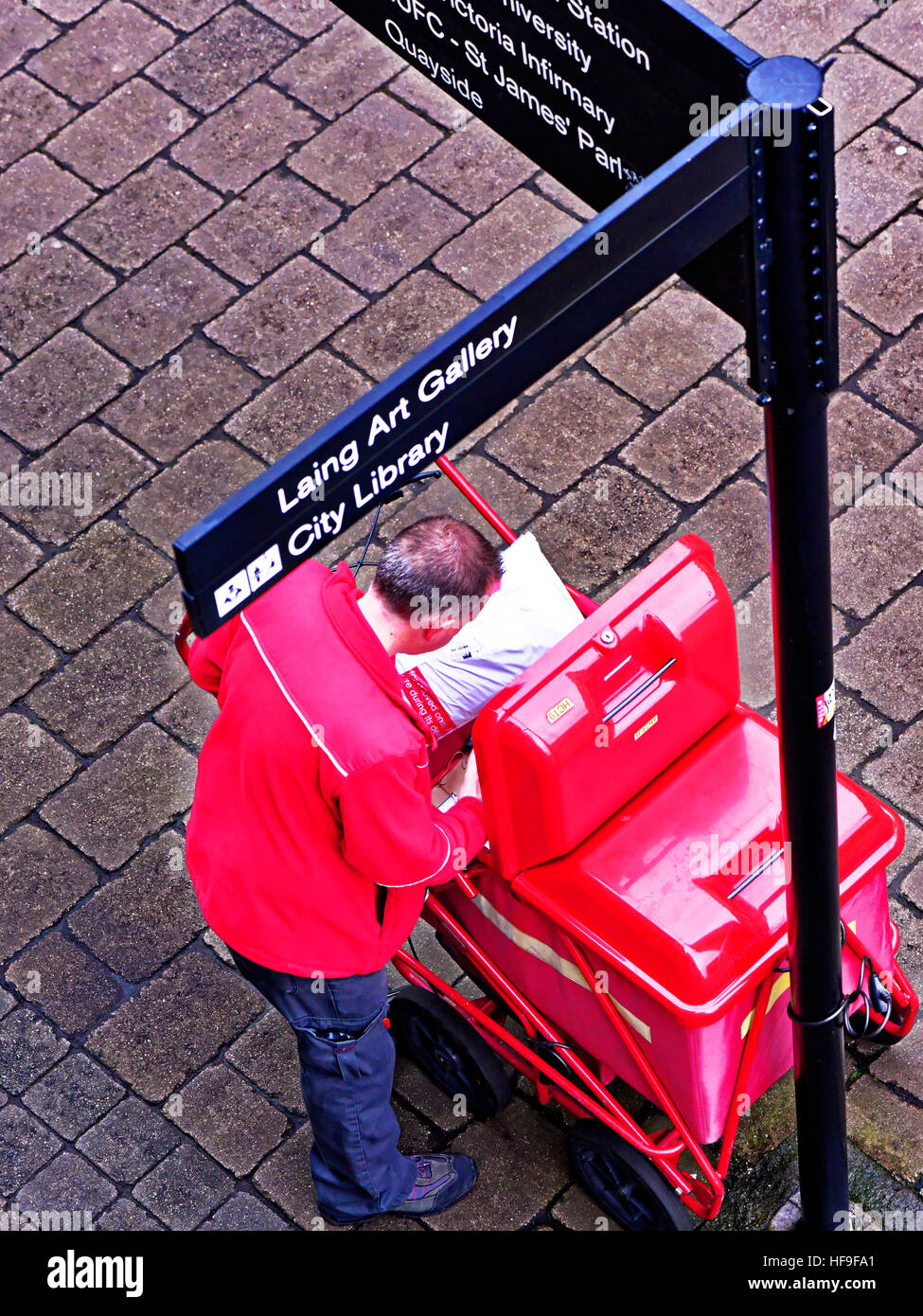 Postman delivering the mail with a mail cart Stock Photo - Alamy