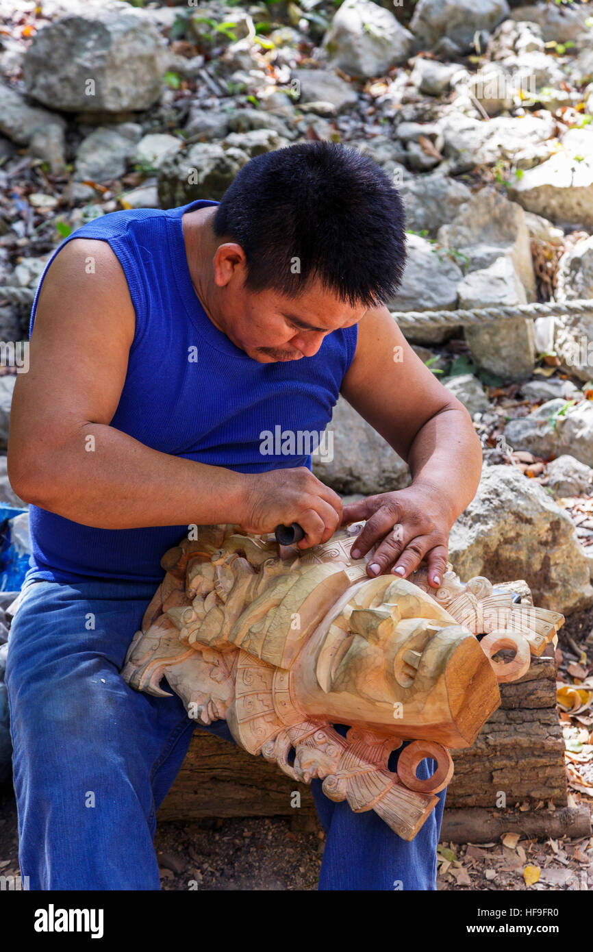 Man hand carving a traditional Mayan scene from wood, to sell at his ...