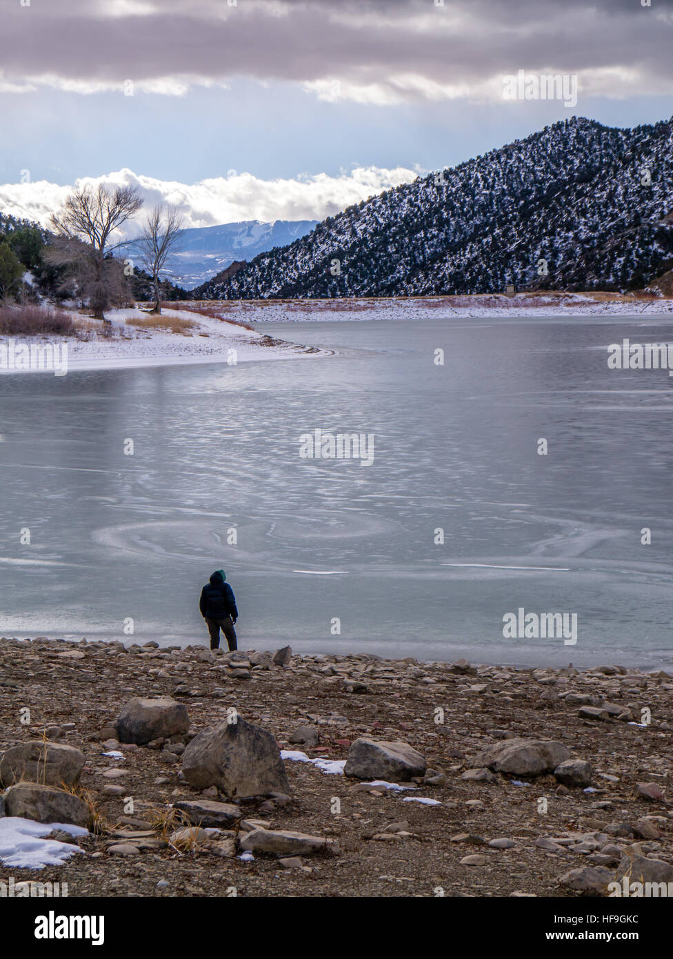 Solitary figure at edge of frozen lake, portrait orientation Stock ...
