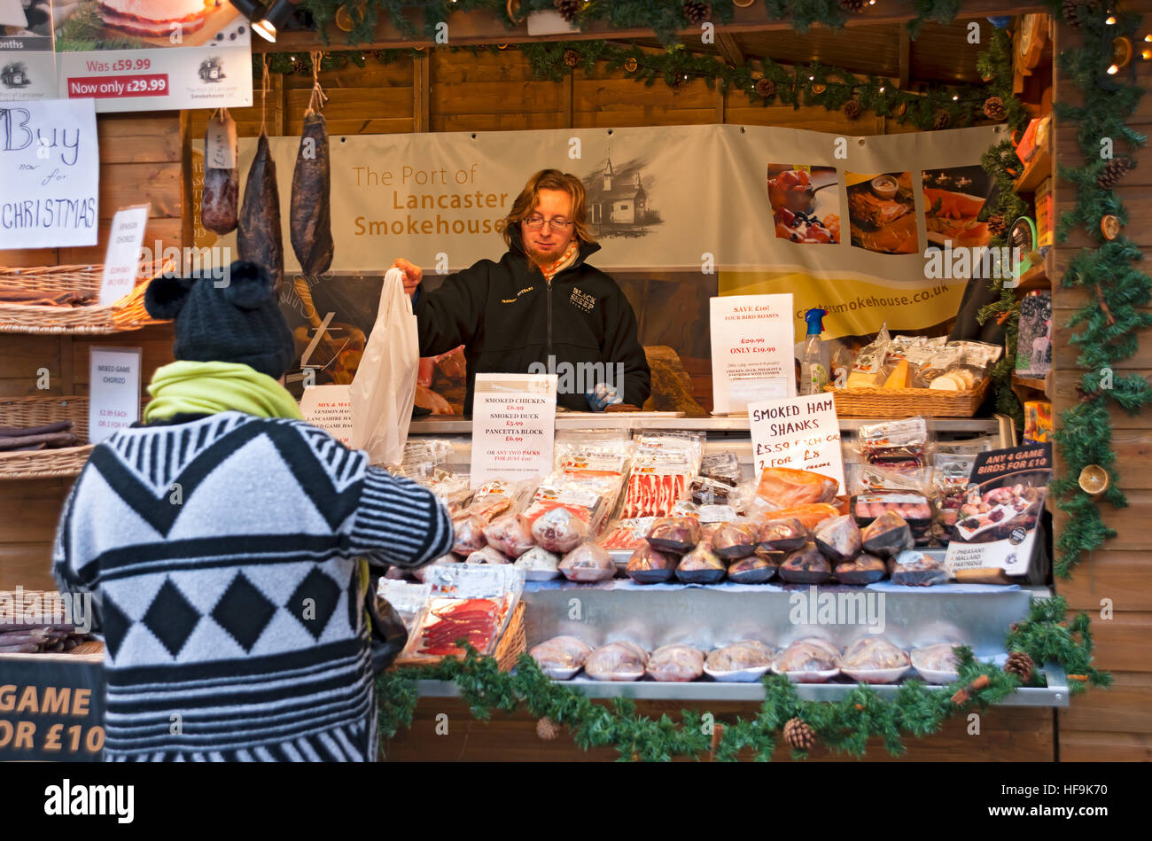Shopper buying meat at Christmas market trader stall at St Nicholas ...