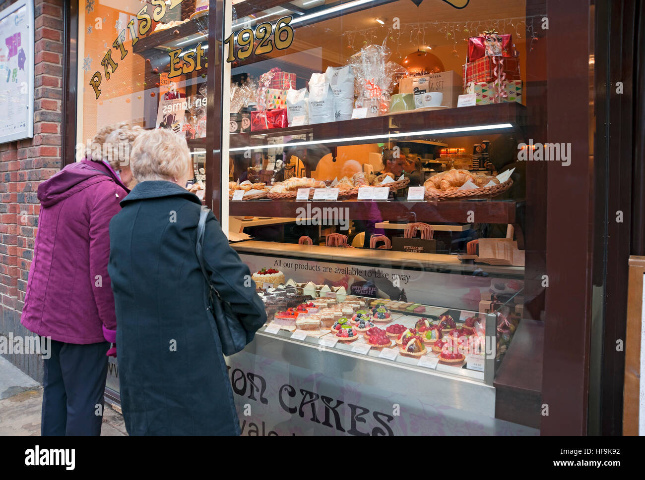 Two women ladies looking in Patisserie Valerie bakery store shop window ...