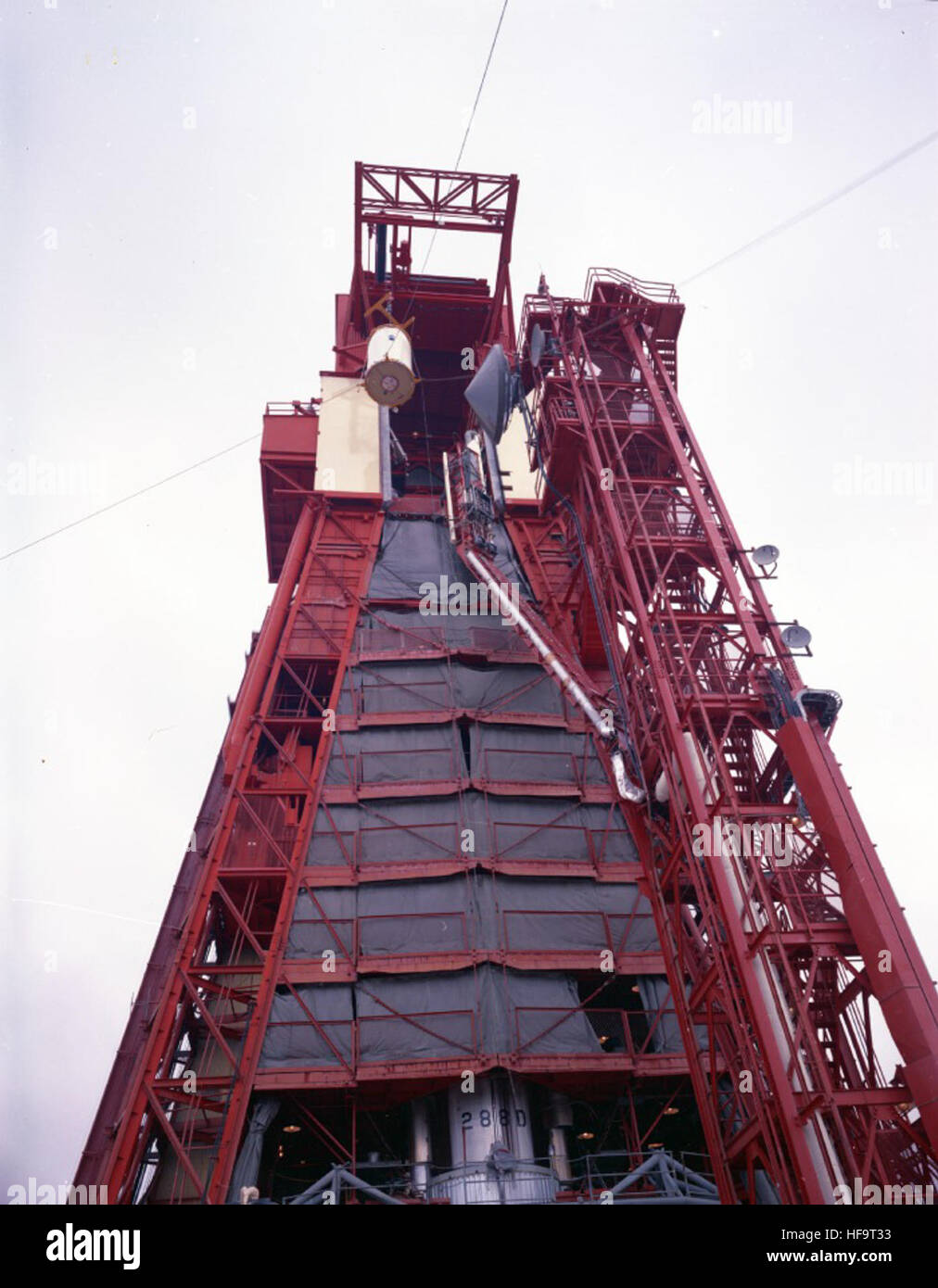 An image of a rocket on the launch pad, with engineers performing final ...