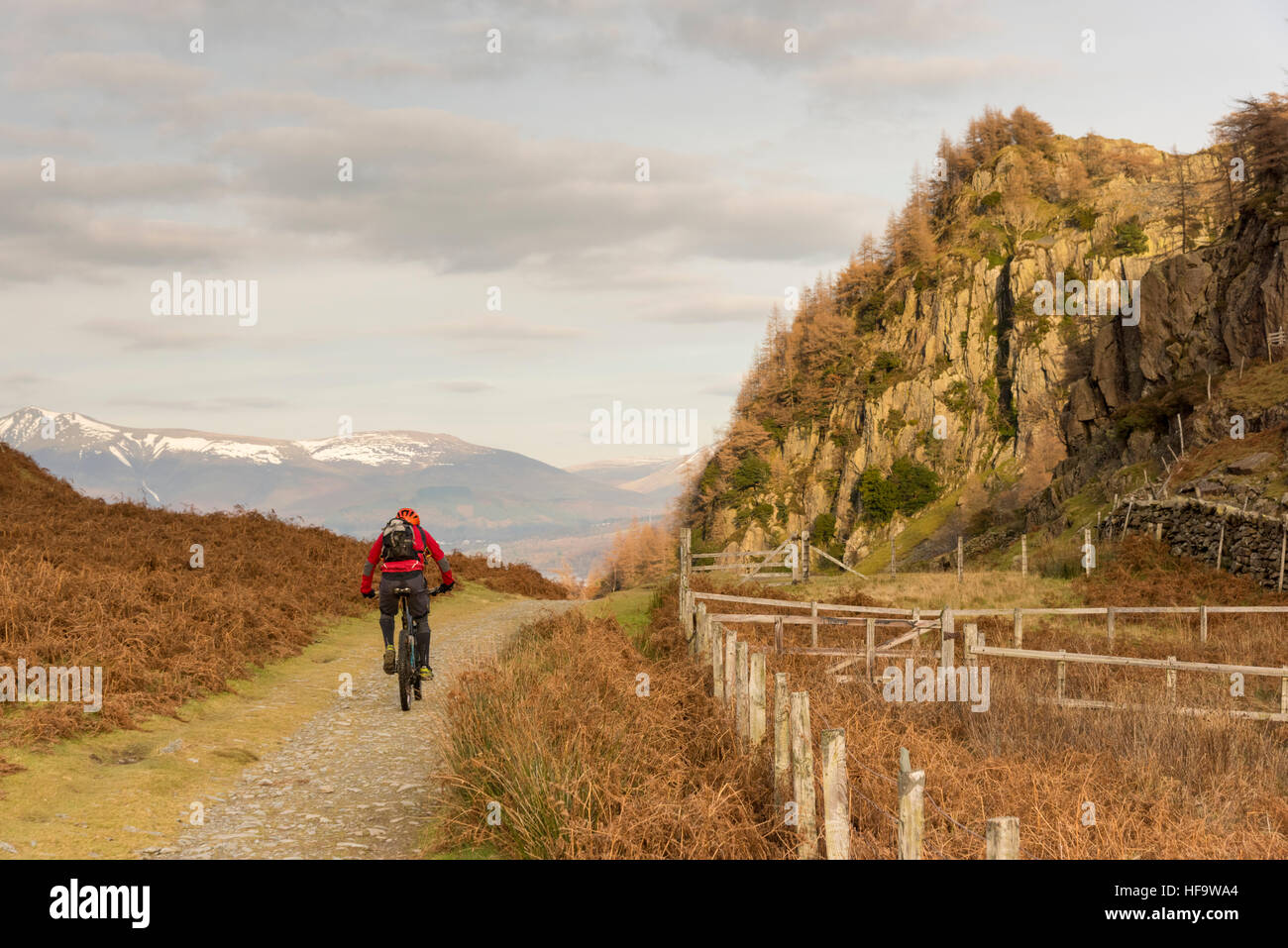 A man on a mountain bike passing Castle crag rock formation near ...