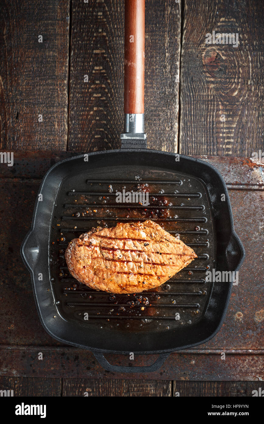 Roast beef steak on pan grill on the table vertical Stock Photo - Alamy