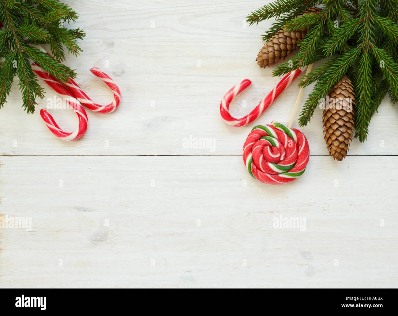 Christmas border with fir tree branches with cones and candy cane on ...