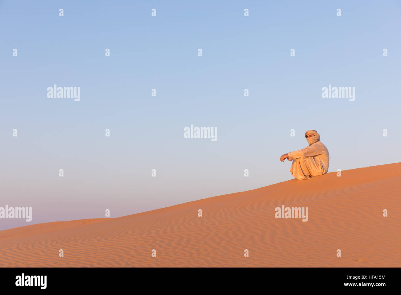 Traditionally dressed Arab man in the desert at sunrise Stock Photo - Alamy