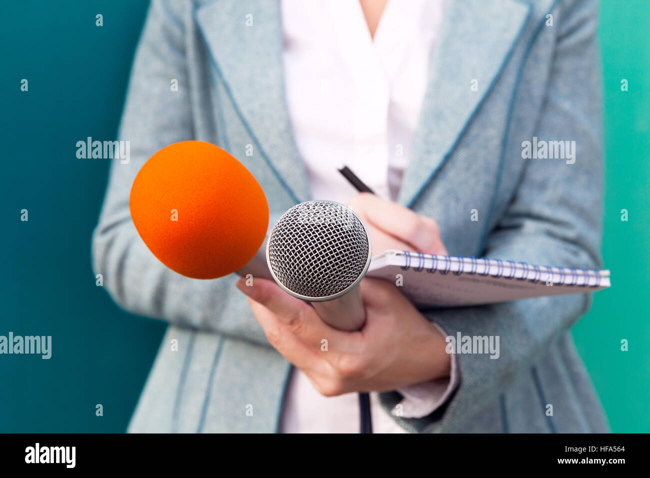 Female reporter taking notes at press conference Stock Photo - Alamy