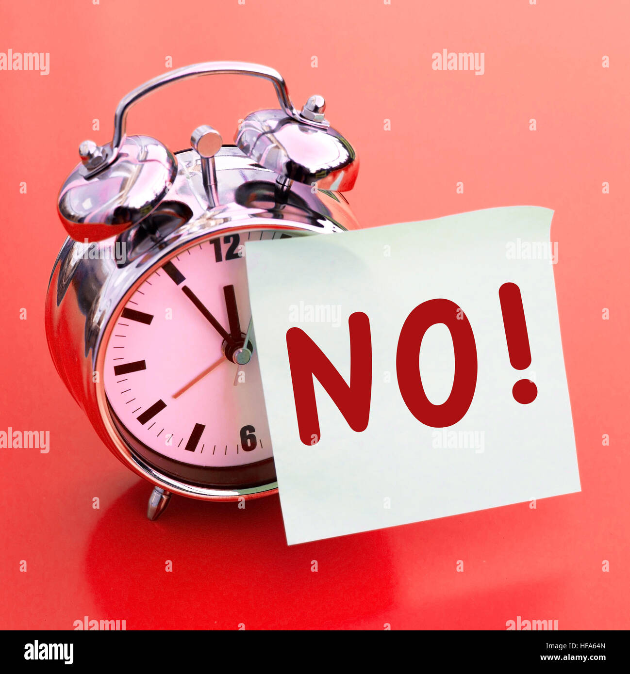 the word No on sticker with alarm clock on red table Stock Photo - Alamy