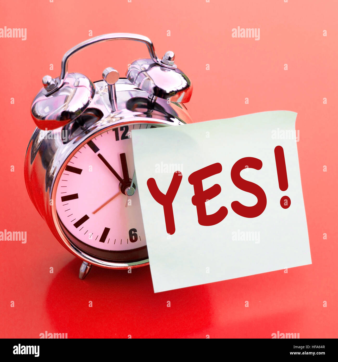 the word Yes on sticker at alarm clock on red table Stock Photo - Alamy