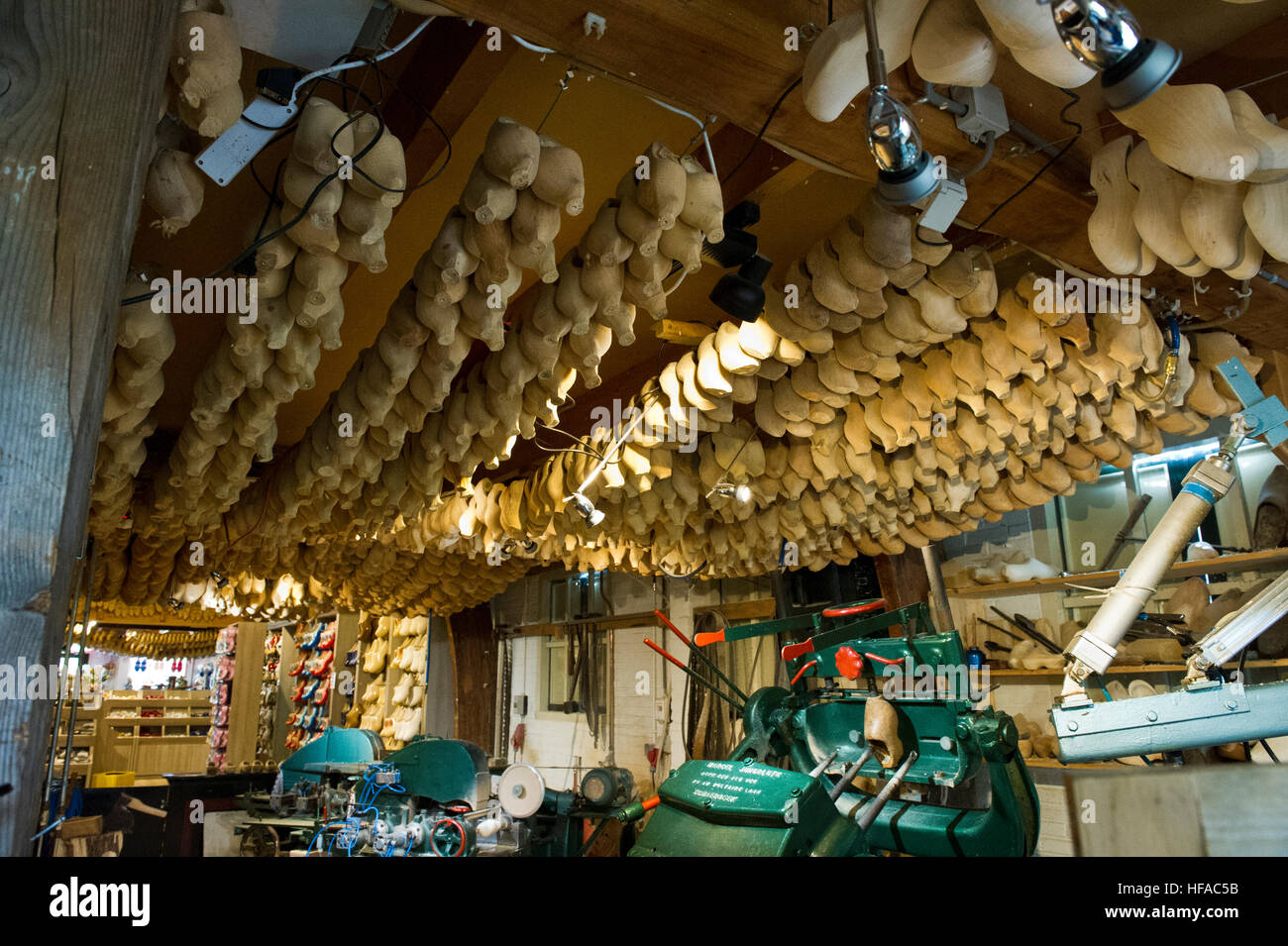 Unfinished wooden clogs hanging from the ceiling in a clogs factory ...