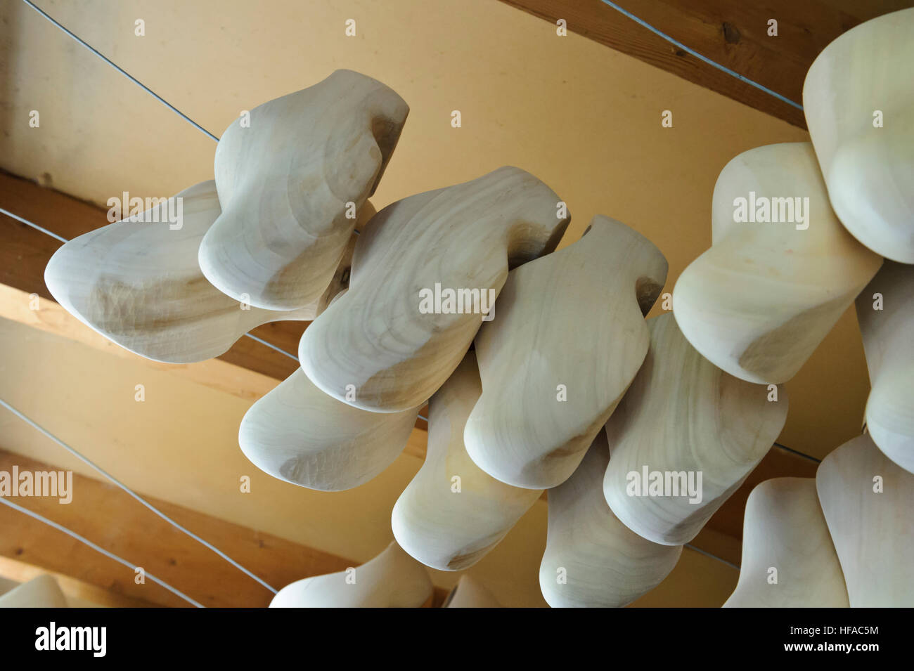 Plain wooden clogs hanging from the ceiling in a clog factory, Holland ...