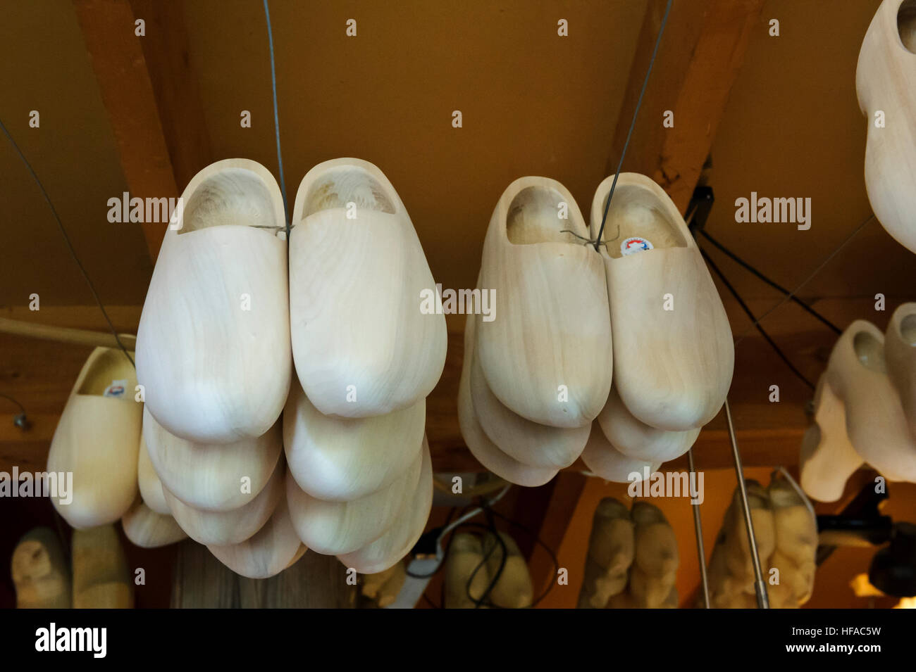 Plain wooden clogs hanging from the ceiling in a clog factory, Holland ...