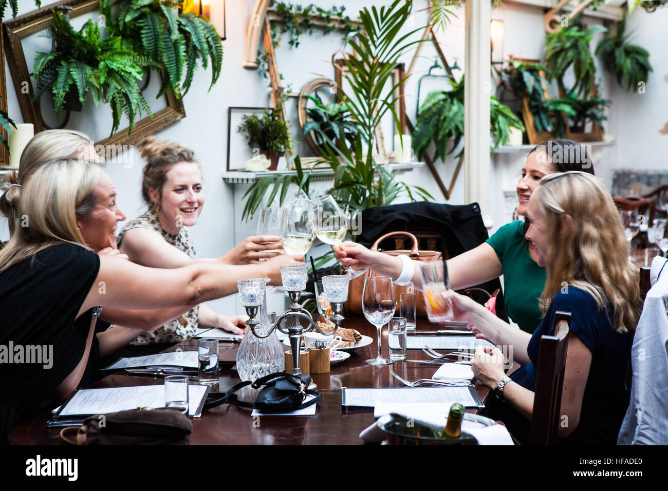 Friends Cheers across a table in a bar restaurant Stock Photo - Alamy