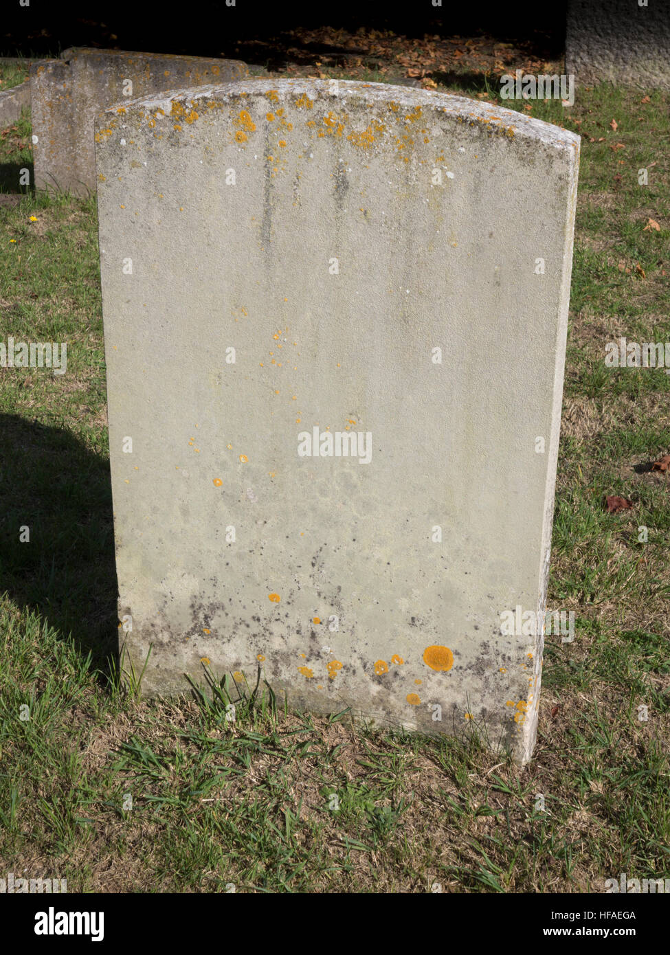 Plain headstone with curved top against a green background Stock Photo ...