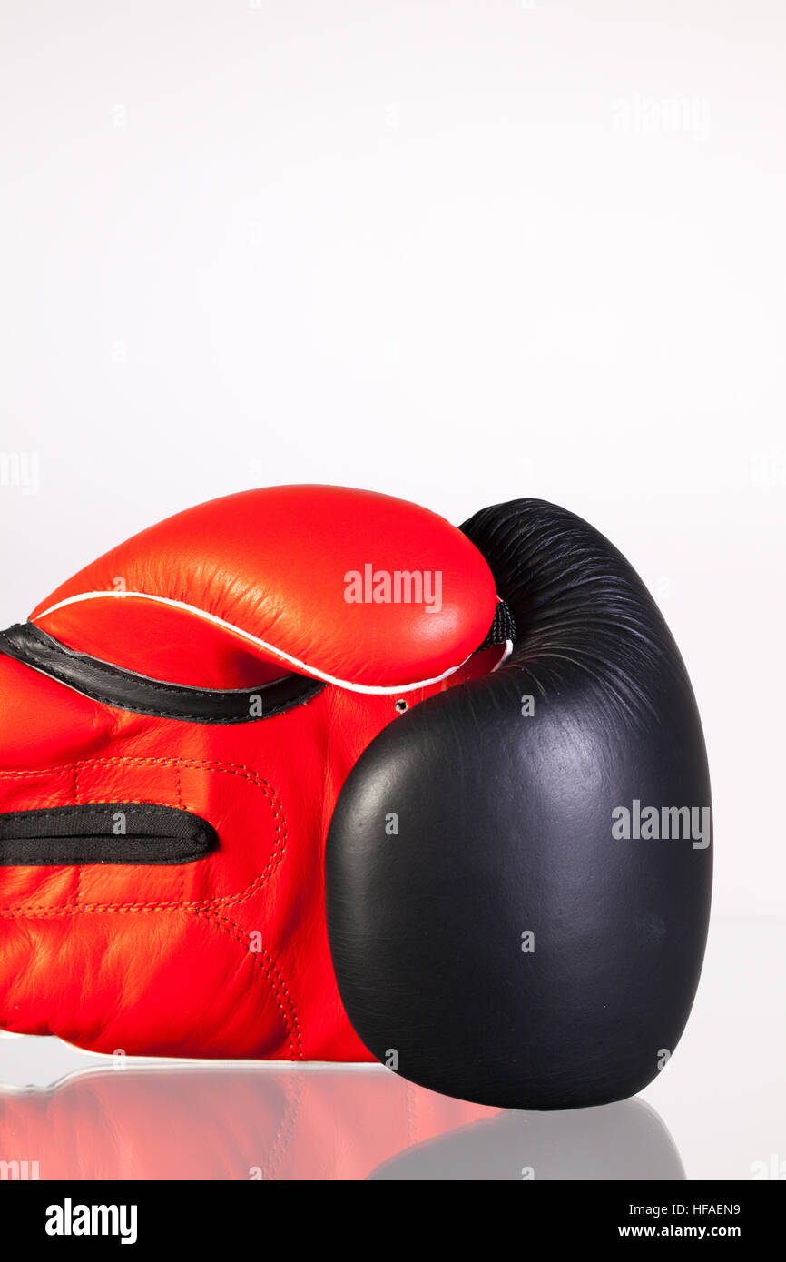 Red and black boxing gloves on a glass table isolated on white ...
