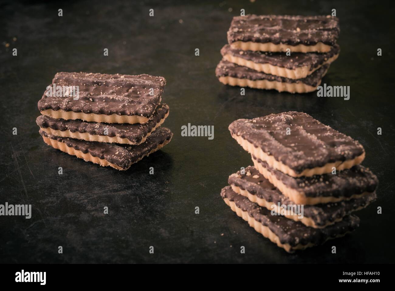 Horizontal photo with few stacks of square biscuits with chocolate on ...