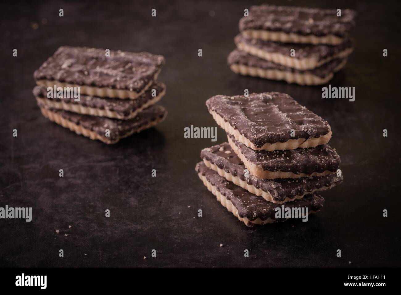 Horizontal photo with few stacks of square biscuits with chocolate on ...