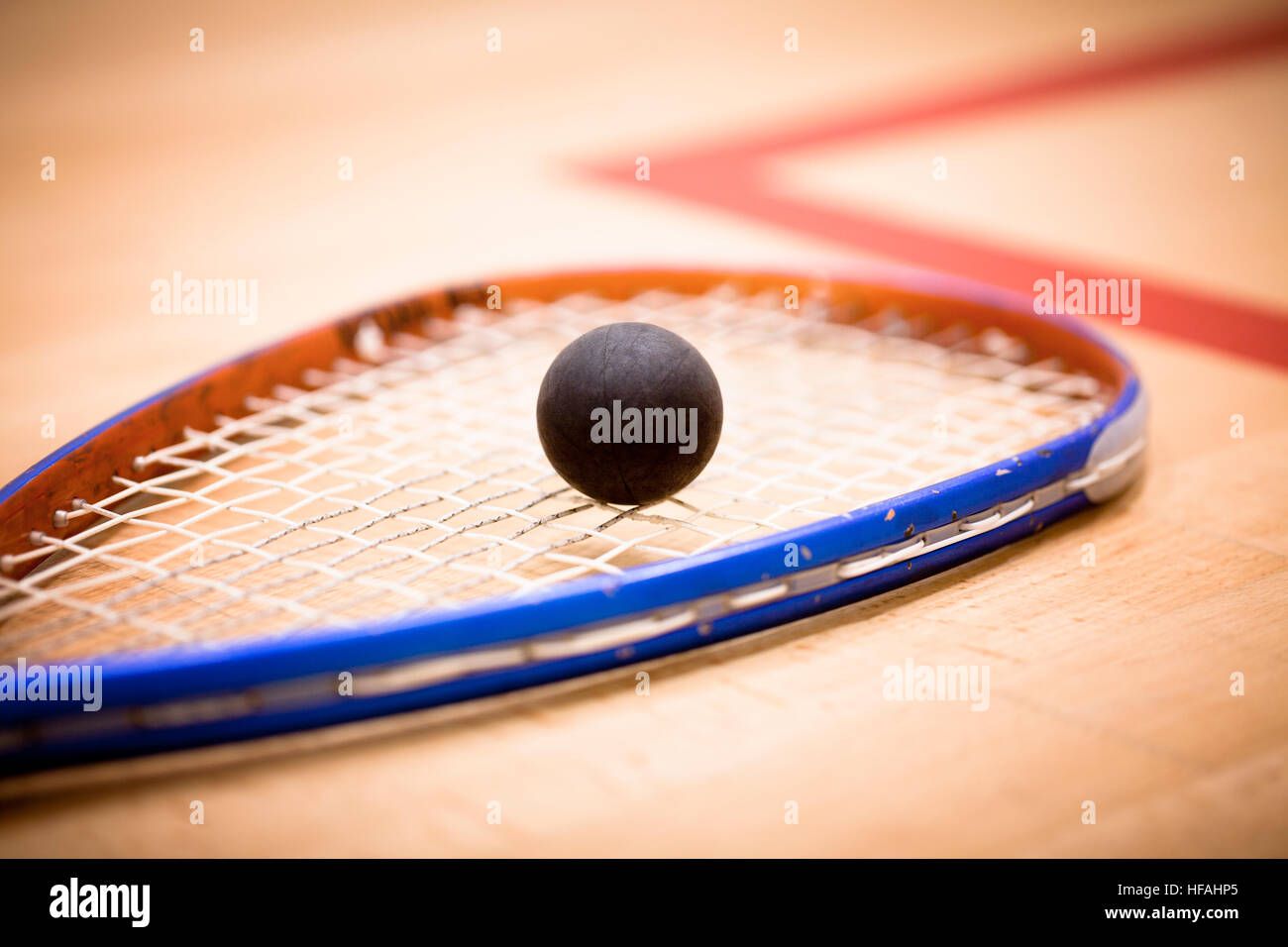 Close up of a squash racket and ball over wooden background Stock Photo ...