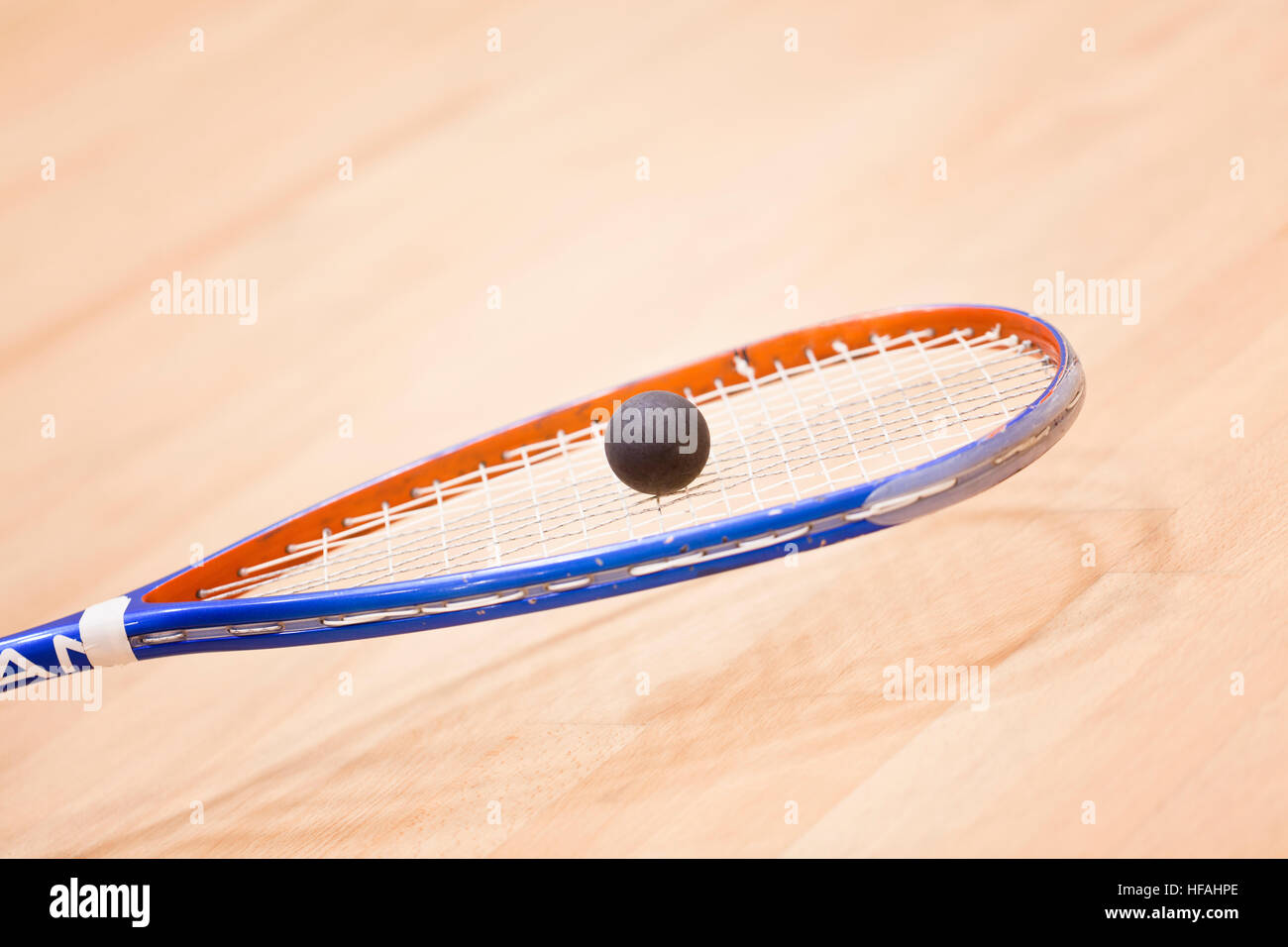 Close up of a squash racket and ball over wooden background Stock Photo ...