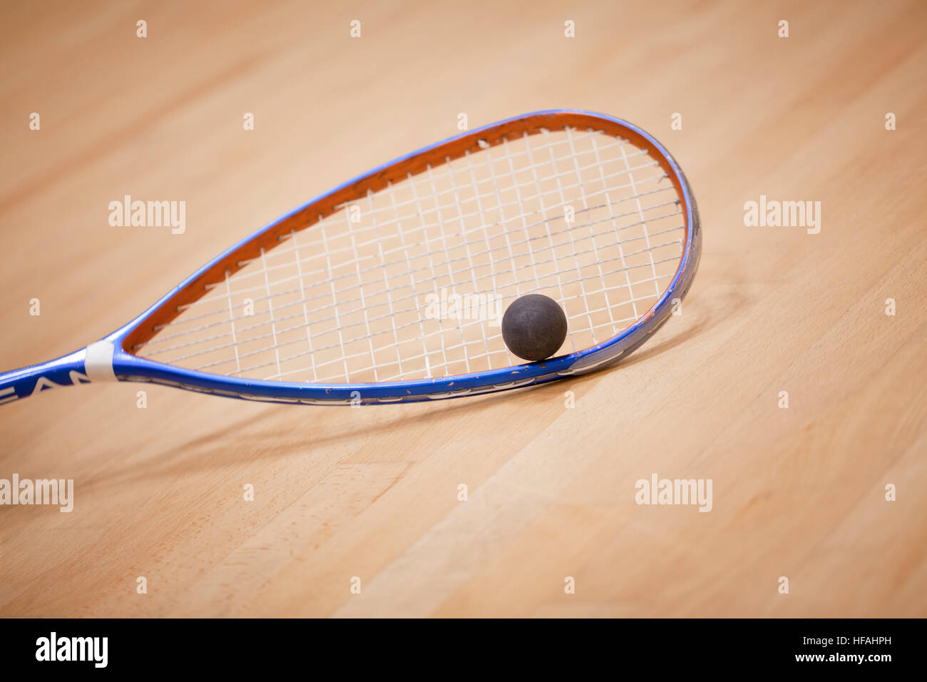 Close up of a squash racket and ball over wooden background Stock Photo ...