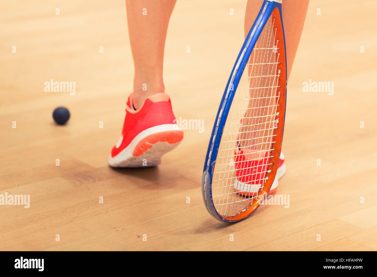 A young female squash player hitting the ball in a squash court Stock ...