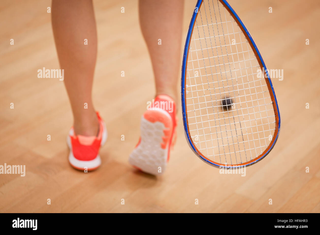 A young female squash player hitting the ball in a squash court Stock ...