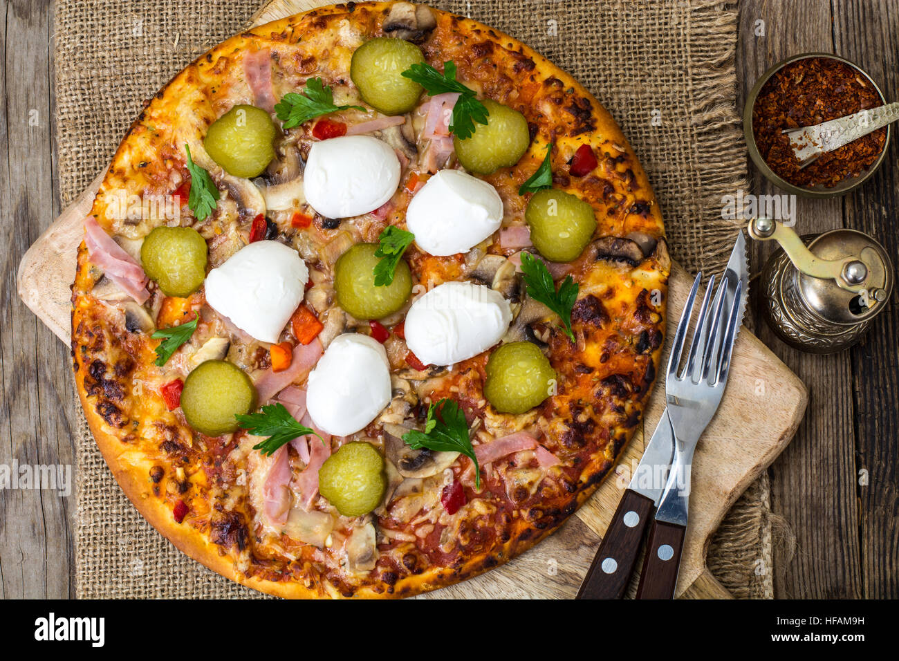 Pizza with ham, mushrooms, gherkin and mozzarella Stock Photo - Alamy