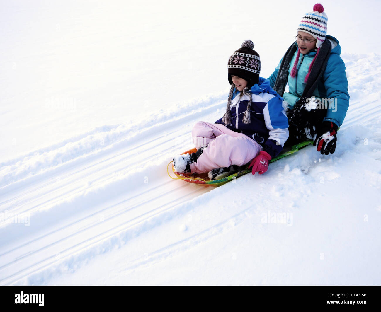 Kids sledding down snowy hill on sled fast speed Stock Photo - Alamy