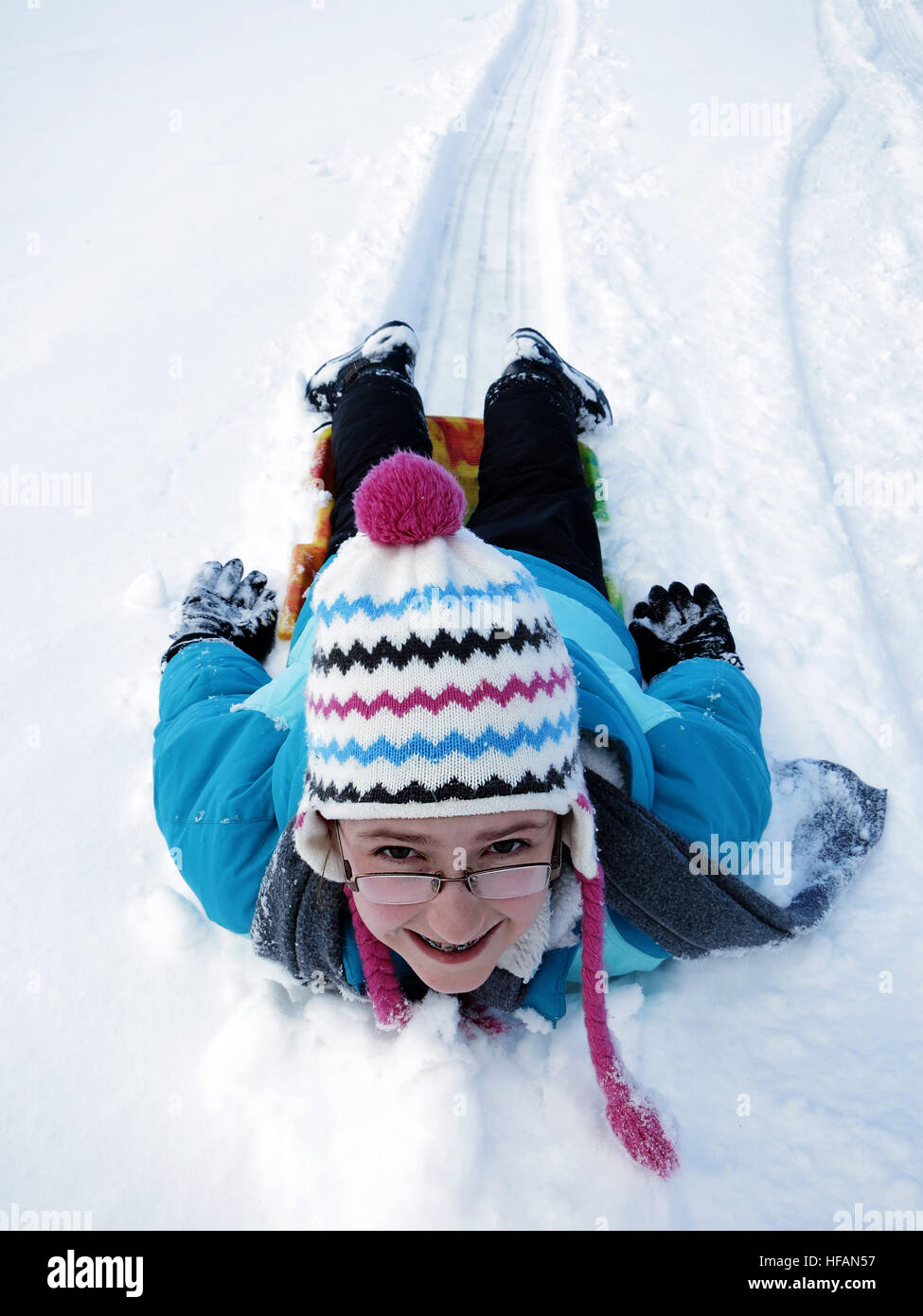 Little Girl sledding down snowy hill on sled fast speed Stock Photo - Alamy