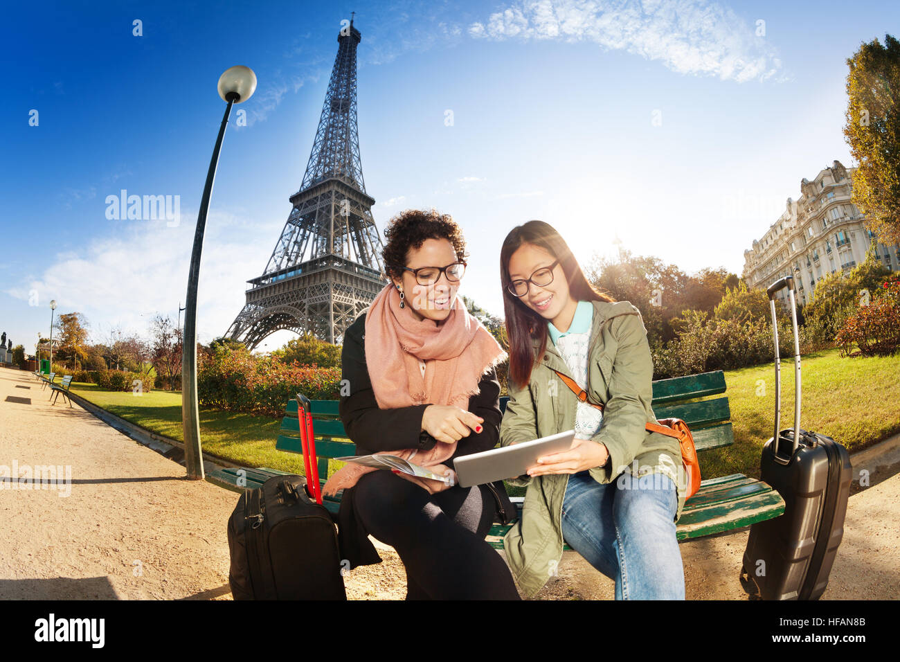 Two tourists sitting against the Eiffel Tower Stock Photo - Alamy