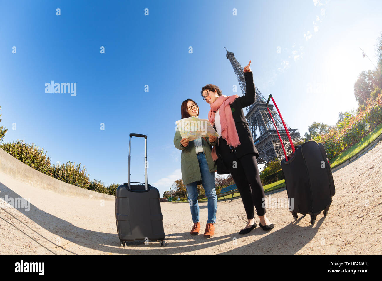 Traveler girls searching right direction on map Stock Photo - Alamy