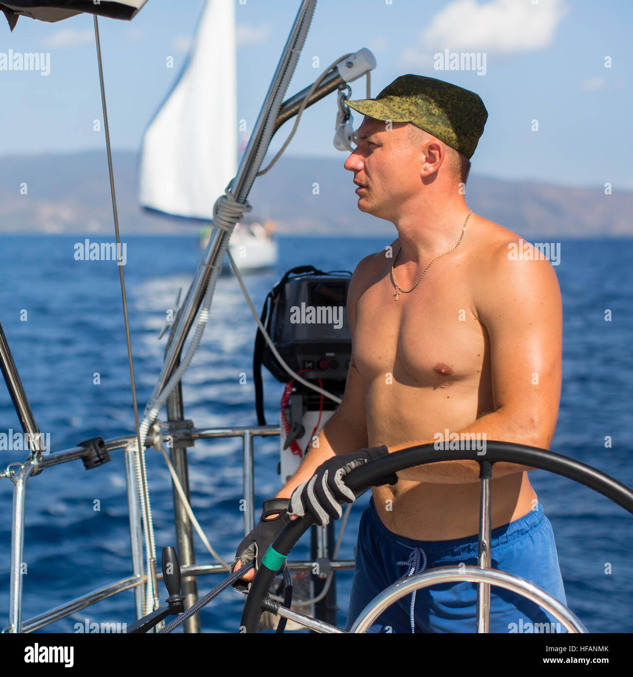 Man at the helm sail boat, the ship controls during sea yacht race ...