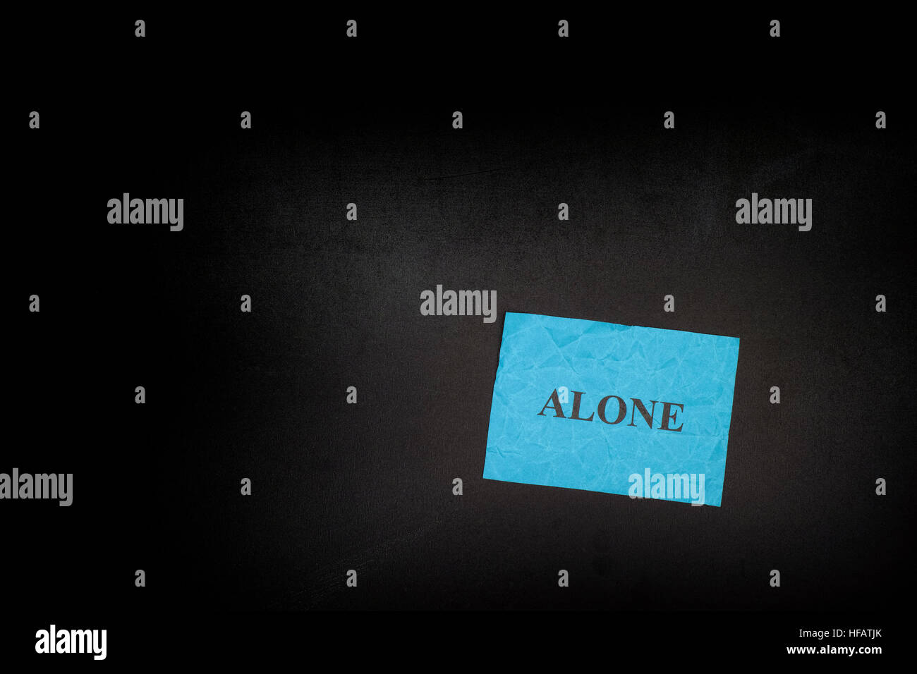 Blue crumpled paper with word Alone on a blackboard. Close up Stock ...