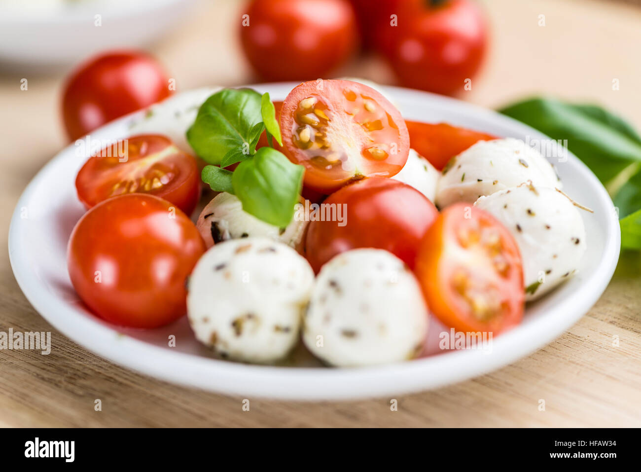 Portion of Mozzarella with Tomatoes on an old wooden table (selective ...