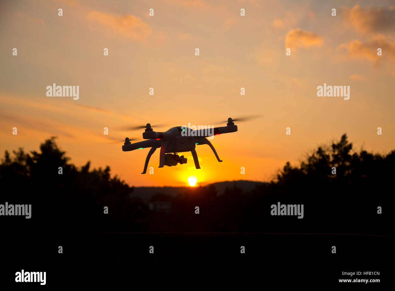 Drone hovering at sunset Stock Photo - Alamy