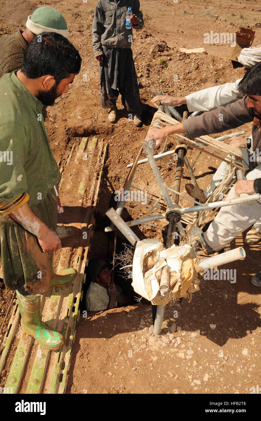 Afghan workers hoist up a worker from a collapsed karez on Shindand Air ...
