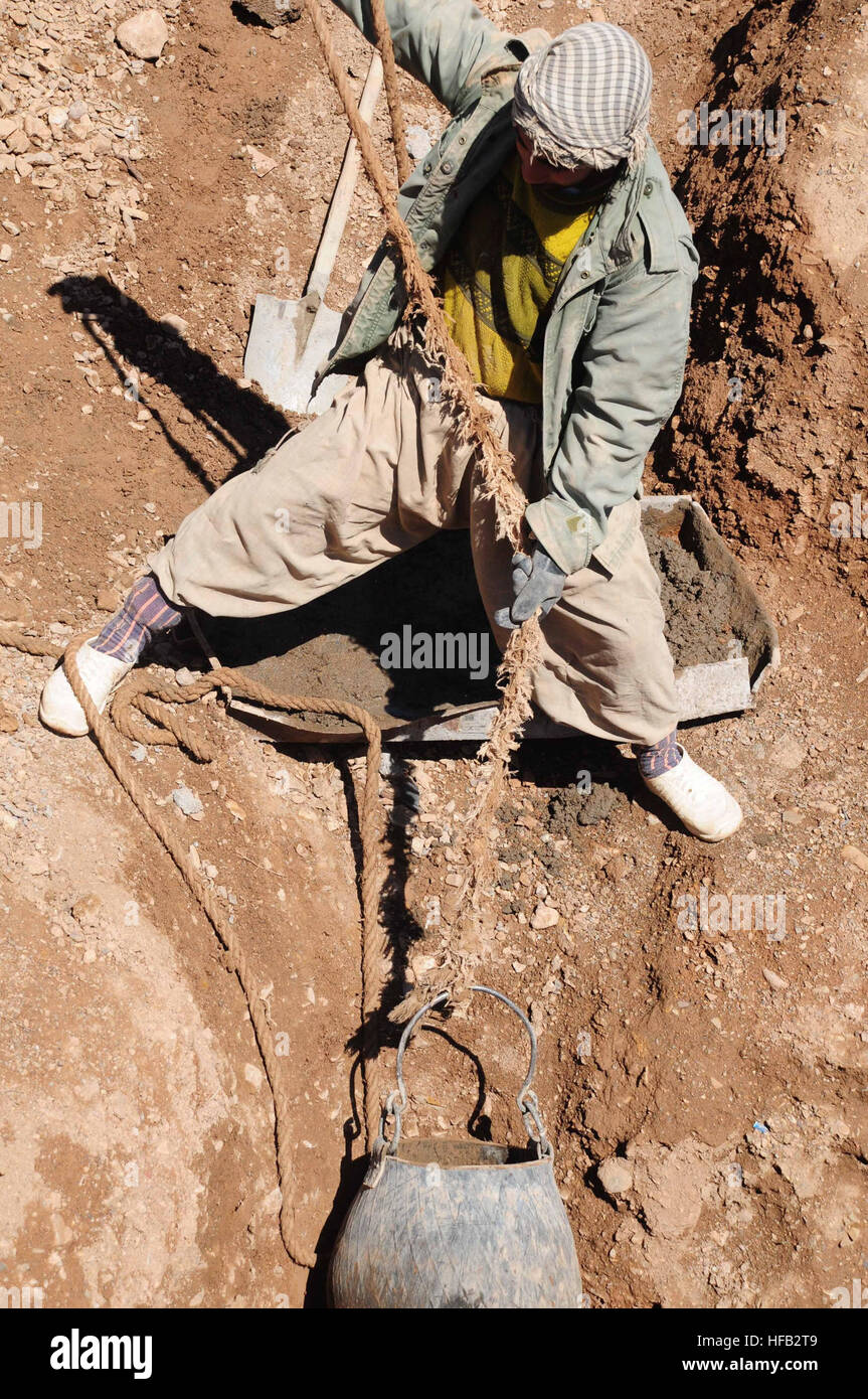 An Afghan worker pulls dirt and rocks from a Karez on Shindand Air Base ...