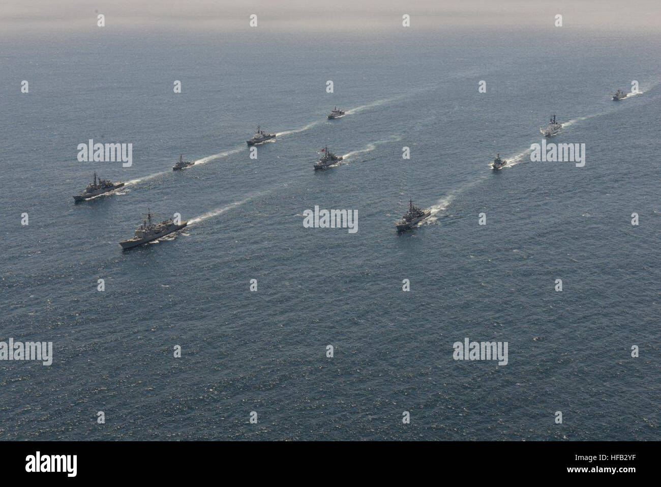 The Coast Guard Cutter Sherman, along with 15 other vessels steam in ...