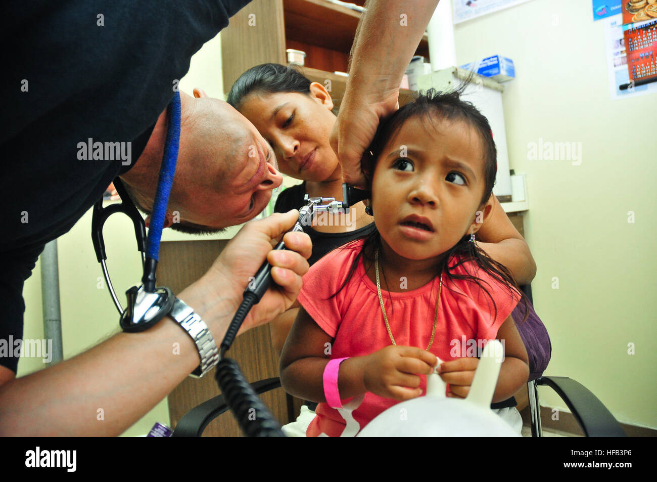 Lt. Cmdr Cory Russell examines the ear canal of a Micronesian girl at ...